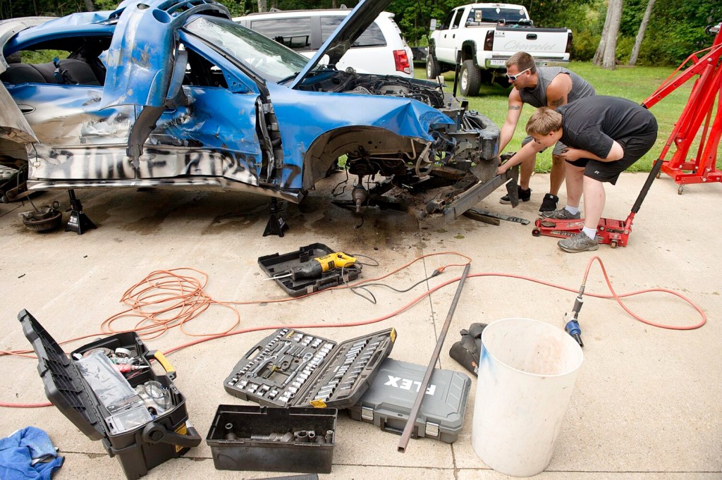 Photo: Father and son rebuilding race car after speedway rollover